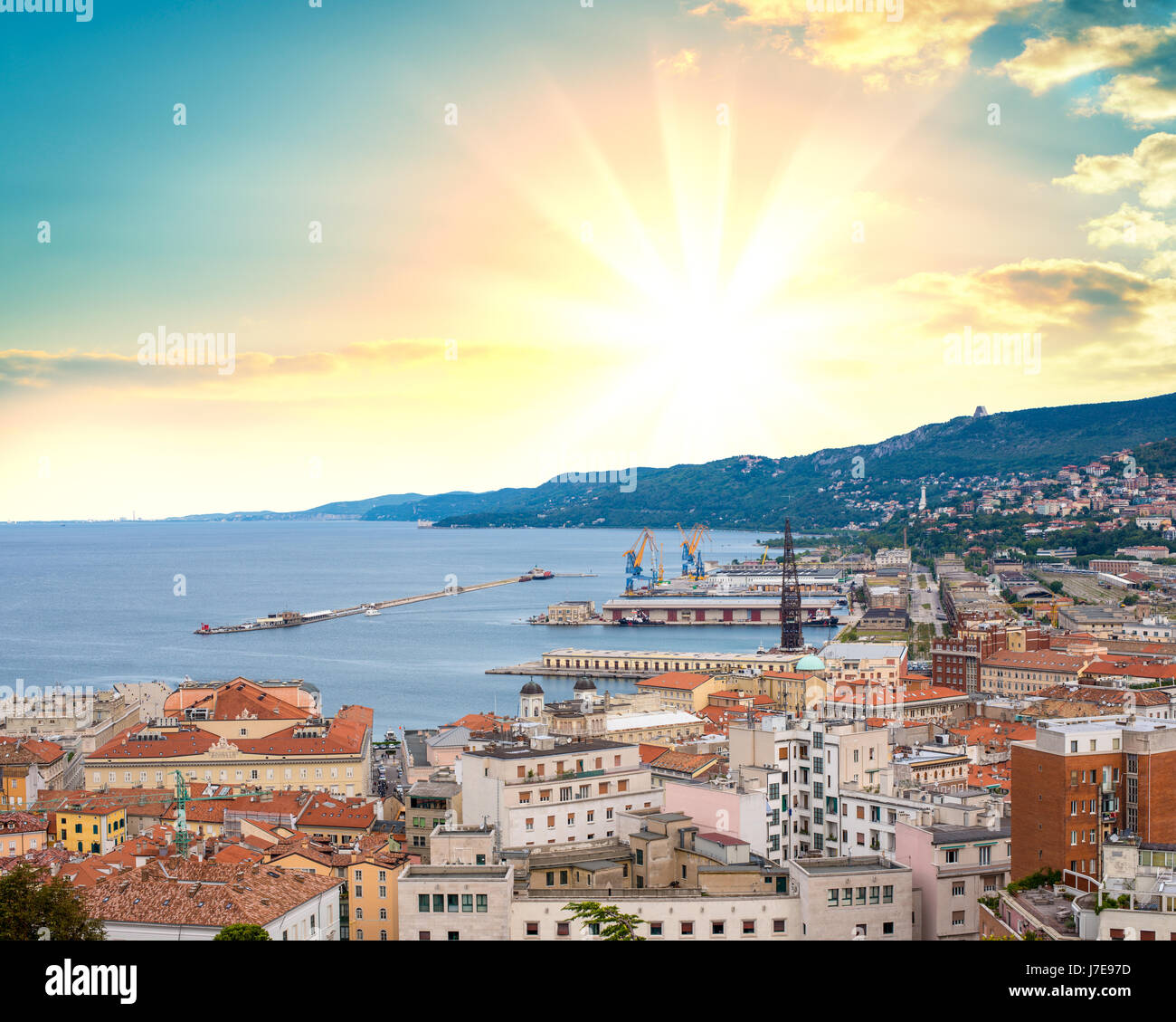 Port city against background of beautiful sunrise Stock Photo - Alamy