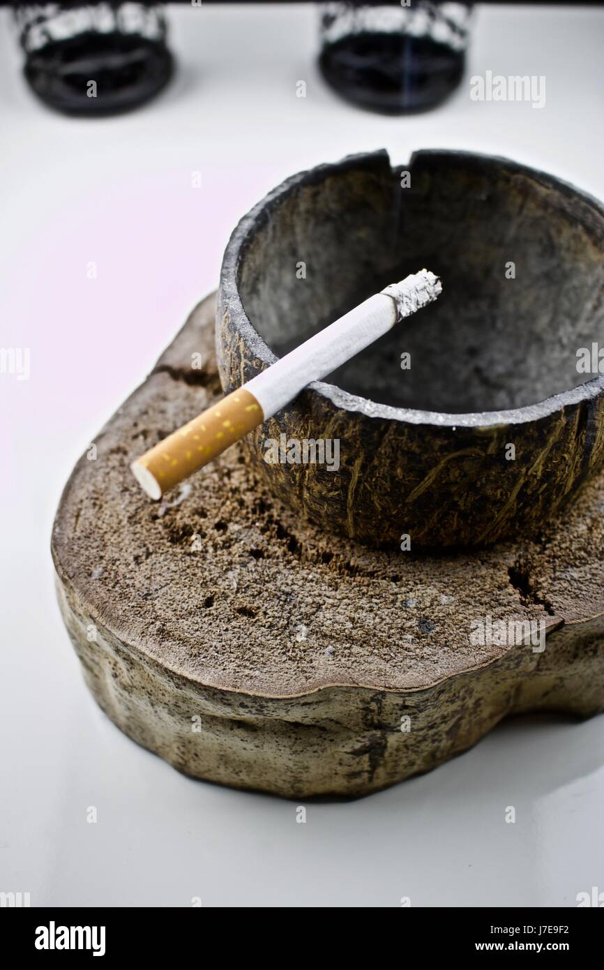 Cigarette in coconut handmade ashtray Stock Photo - Alamy