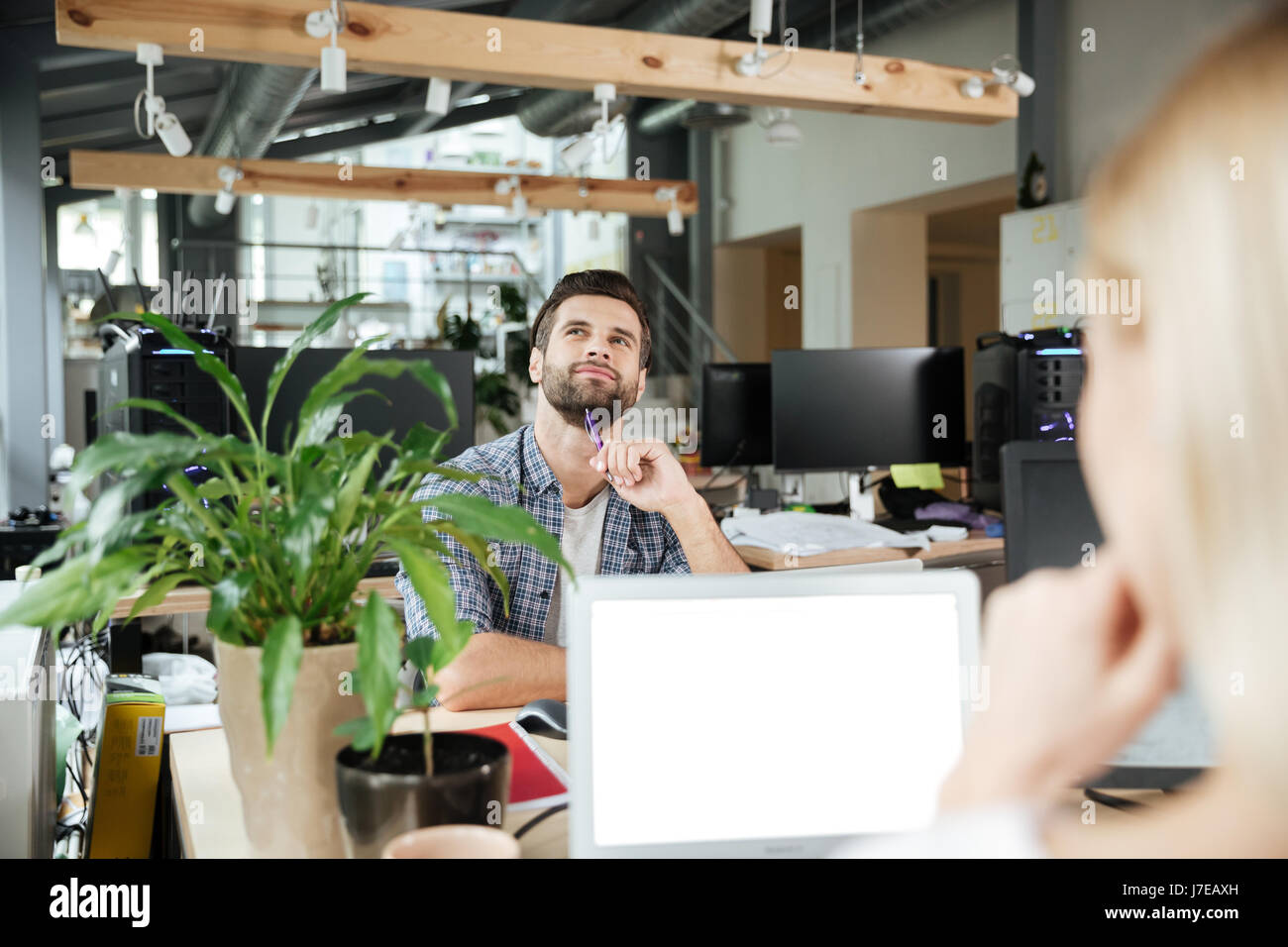 Photo of young happy two colleagues in office coworking while using ...