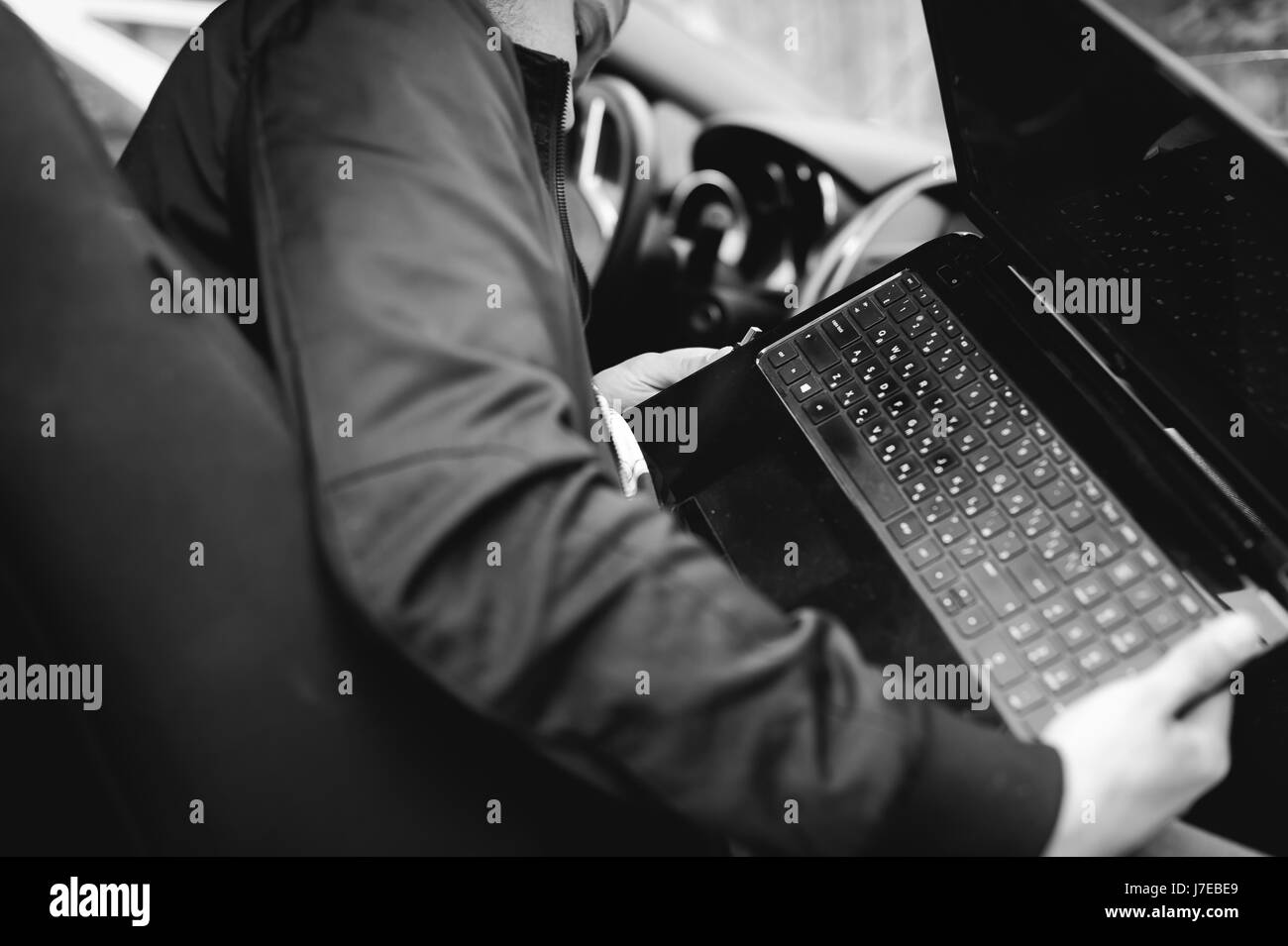 Professional man with a laptop in car tunes tuning control system ...