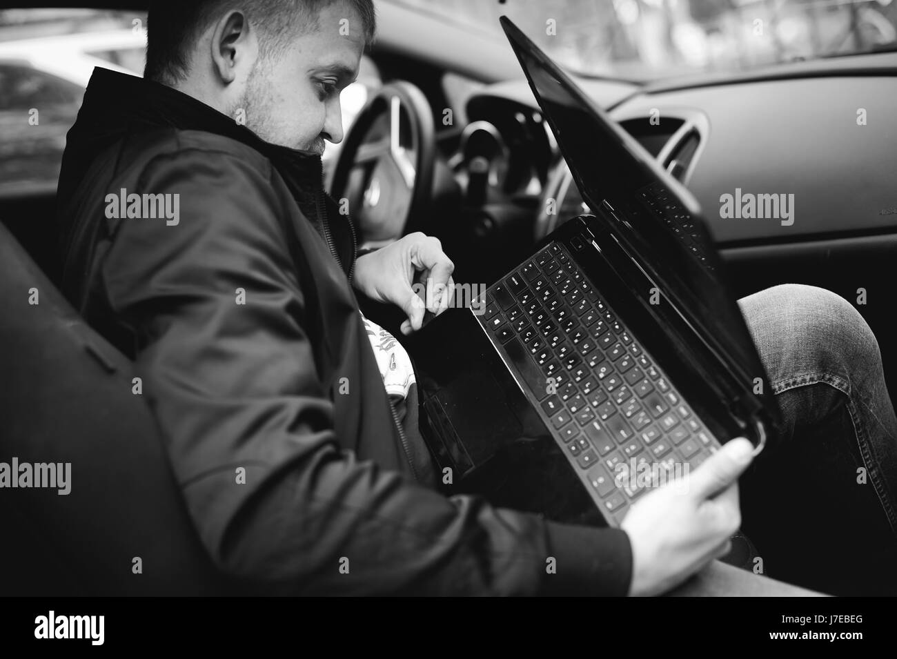 Professional man with a laptop in car tunes tuning control system ...