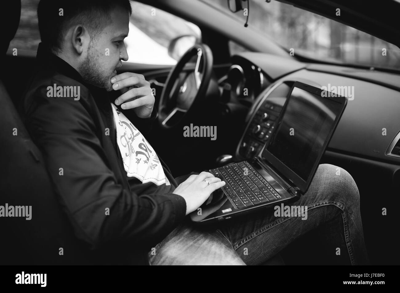 Professional man with a laptop in car tunes tuning control system ...
