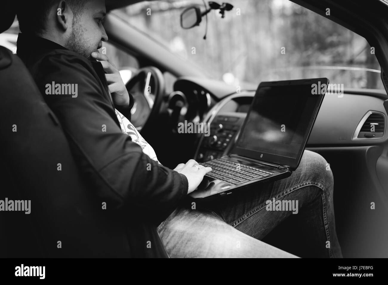 Professional man with a laptop in car tunes tuning control system ...