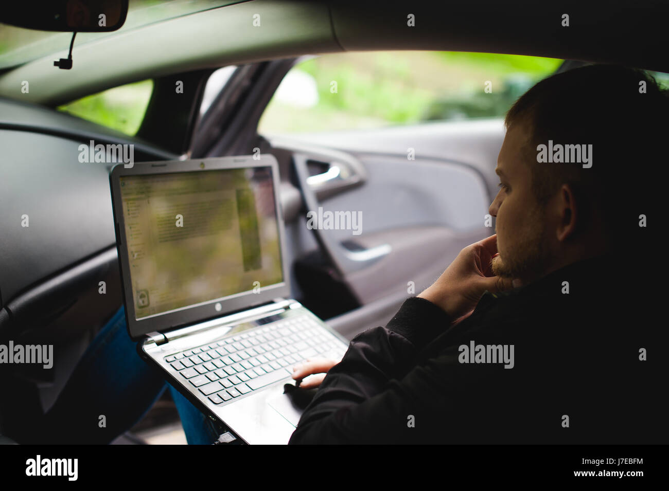 Professional man with a laptop in car tunes tuning control system ...