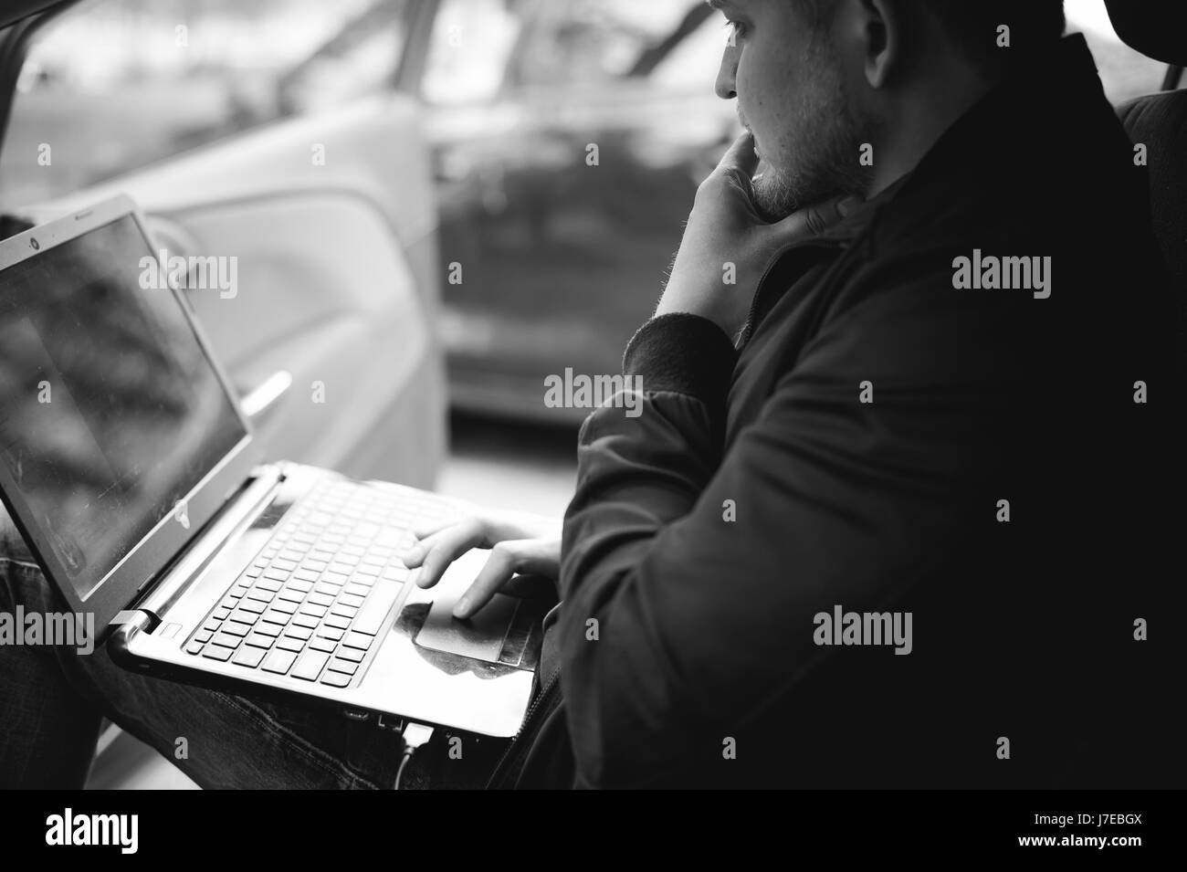 Professional man with a laptop in car tunes tuning control system ...