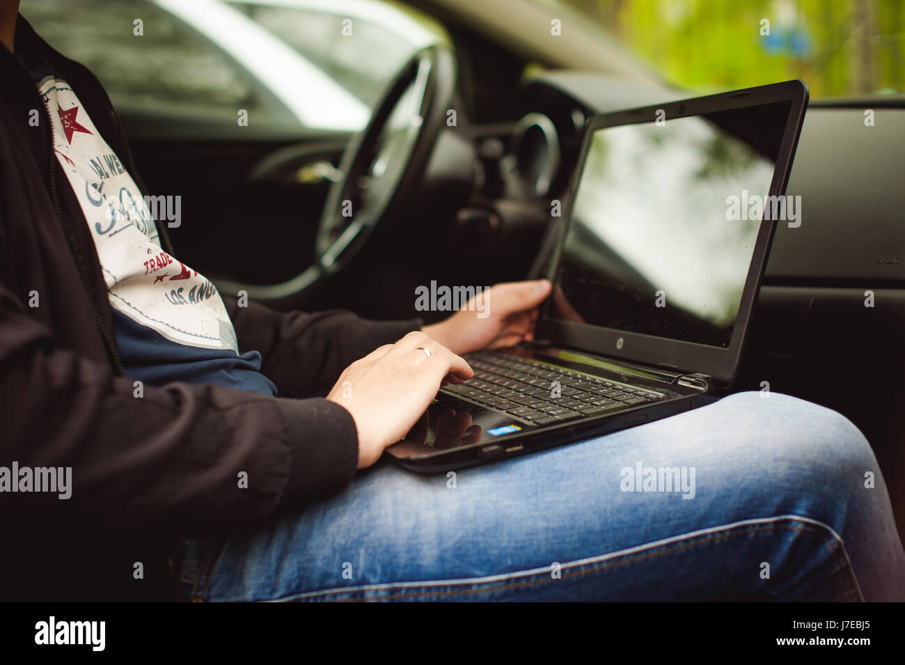 Professional man with a laptop in car tunes tuning control system ...