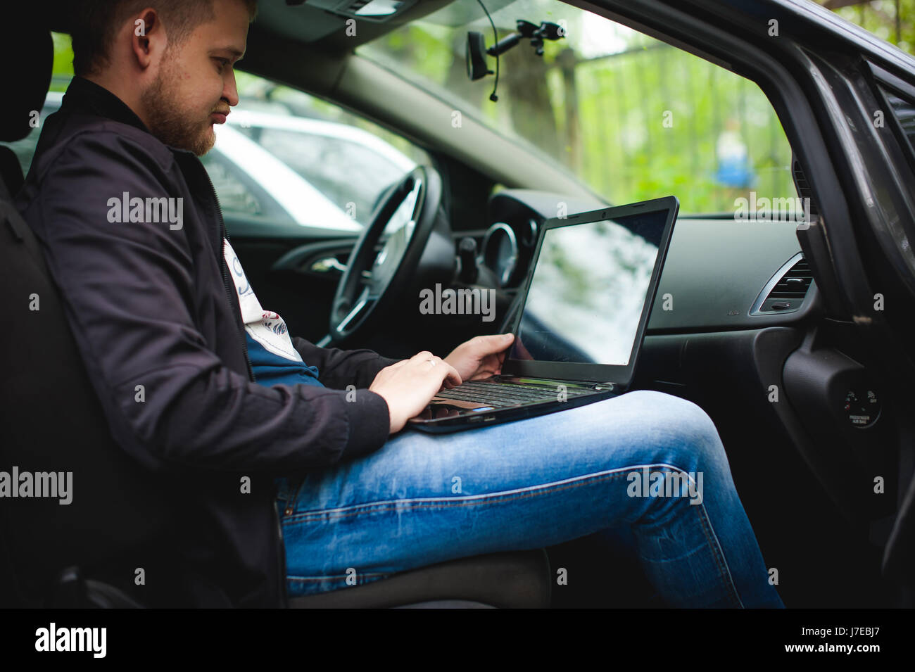 Professional man with a laptop in car tunes tuning control system ...