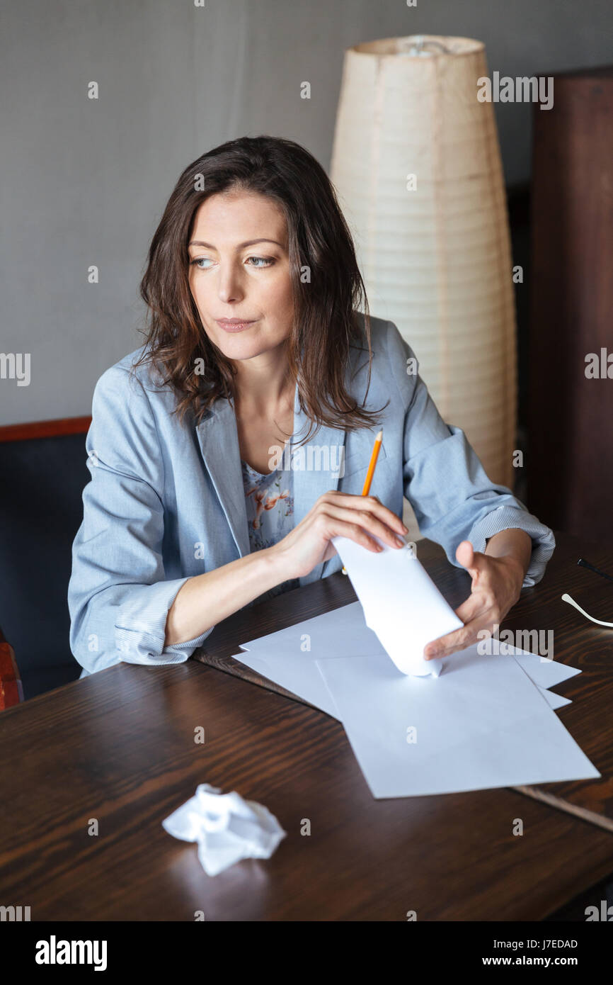 Photo of thinking concentrated woman writer sitting indoors. Looking ...