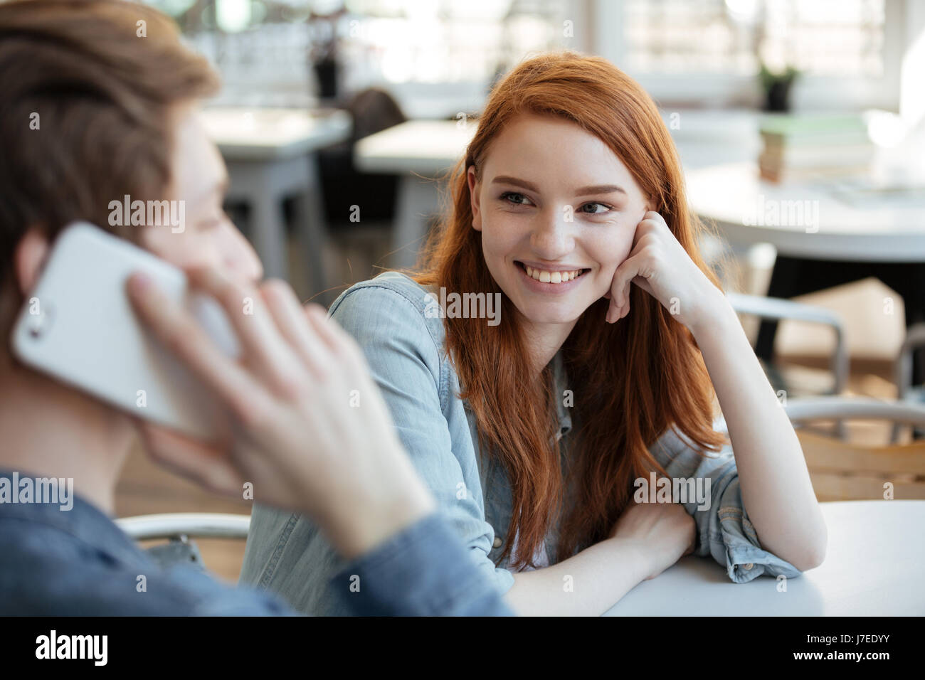 Pretty young woman looking at her man while he talking on phone Stock ...