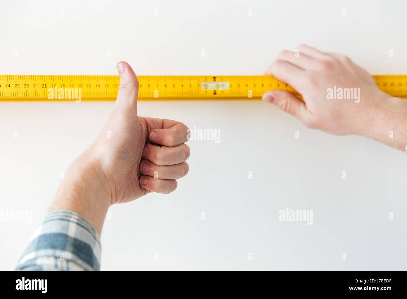 Close up man showing thumb up and using ruler isolated Stock Photo - Alamy