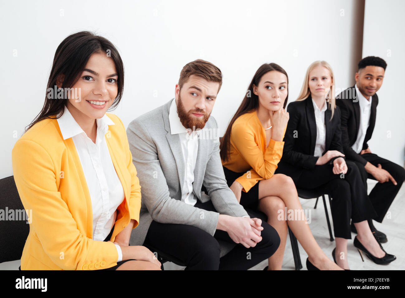 Image of a group of confused colleagues sitting in office looking at ...