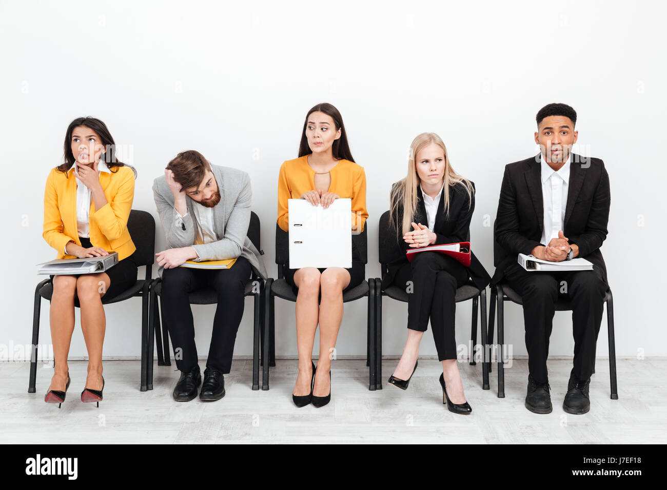 Picture of a group of confused colleagues sitting in office. Looking ...