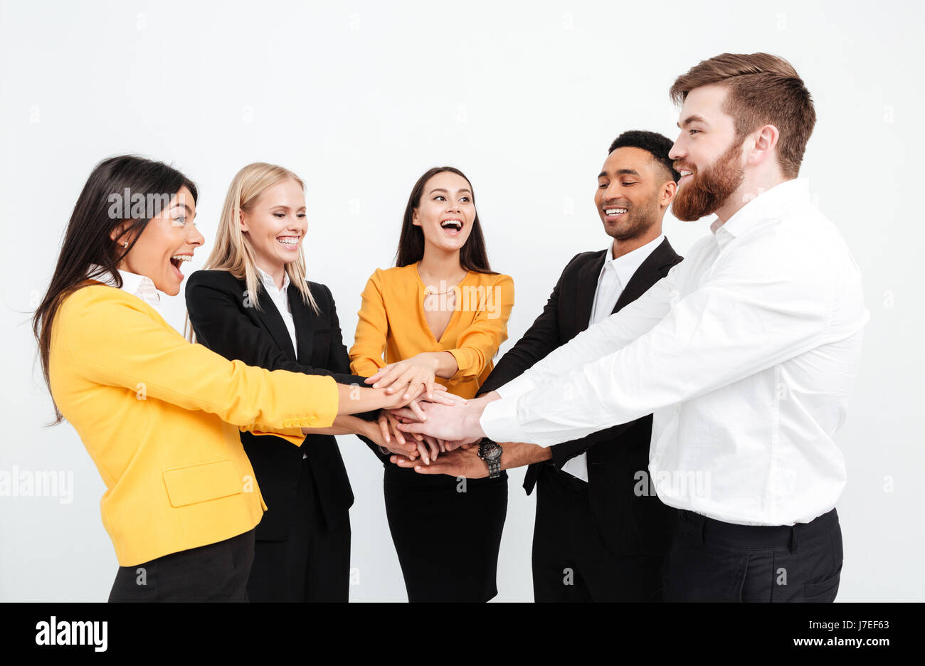 Image of a group of happy colleagues standing in office. Looking aside ...