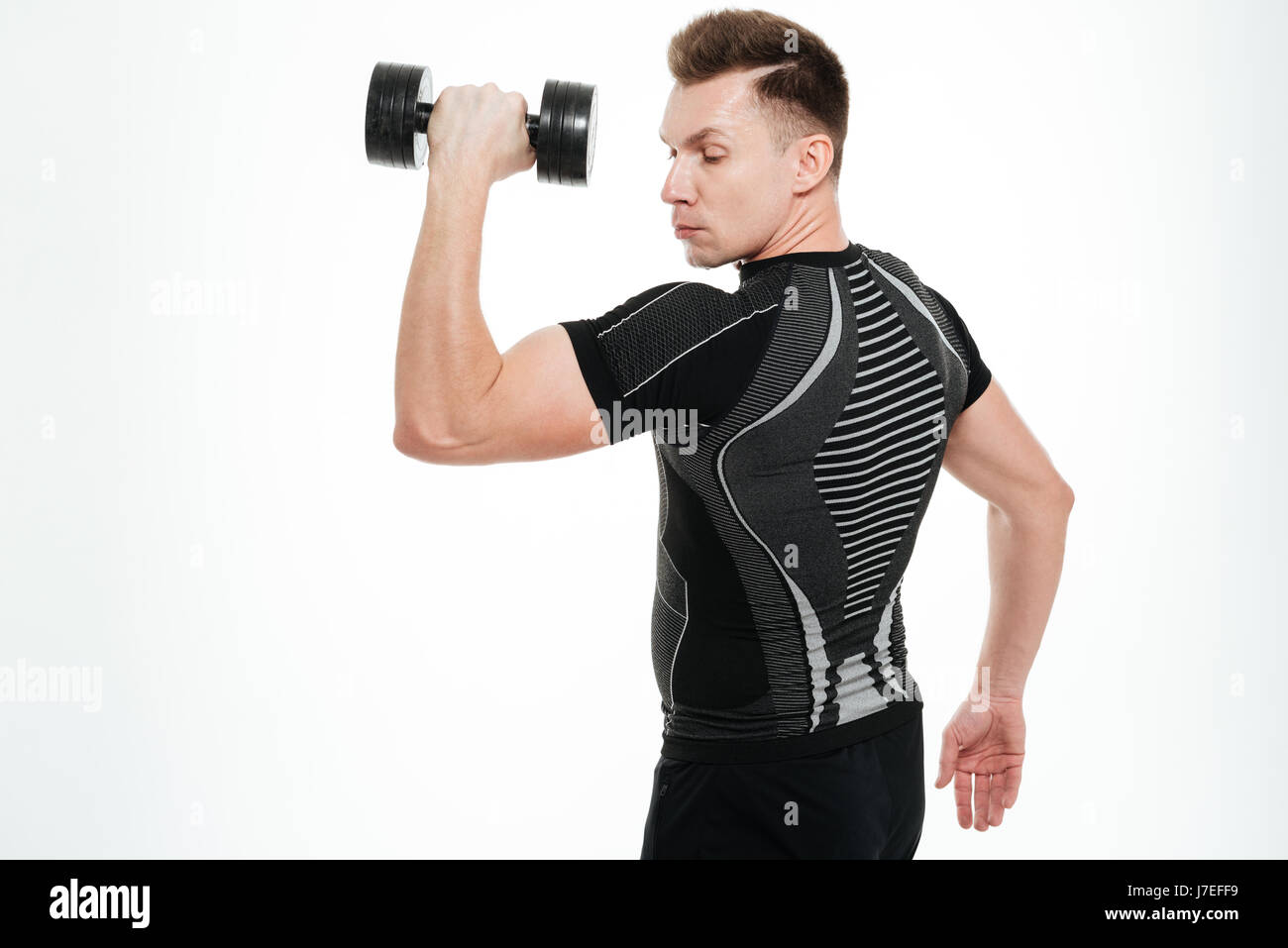 Picture of handsome strong sportsman make sports exercises with dumbbell isolated over white ...