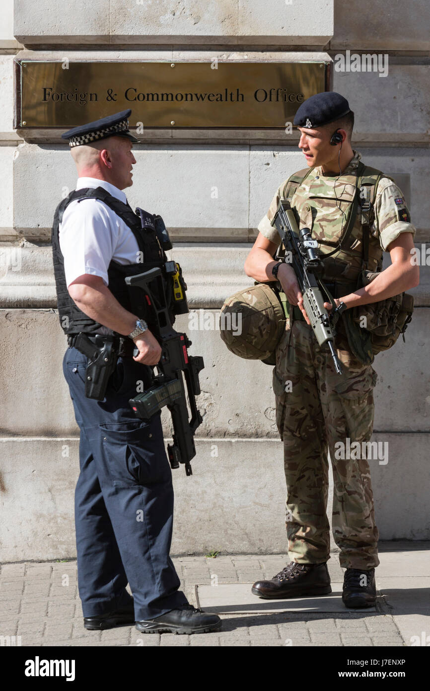 London, UK. 24 May 2017. An armed police officer and a soldier guard ...