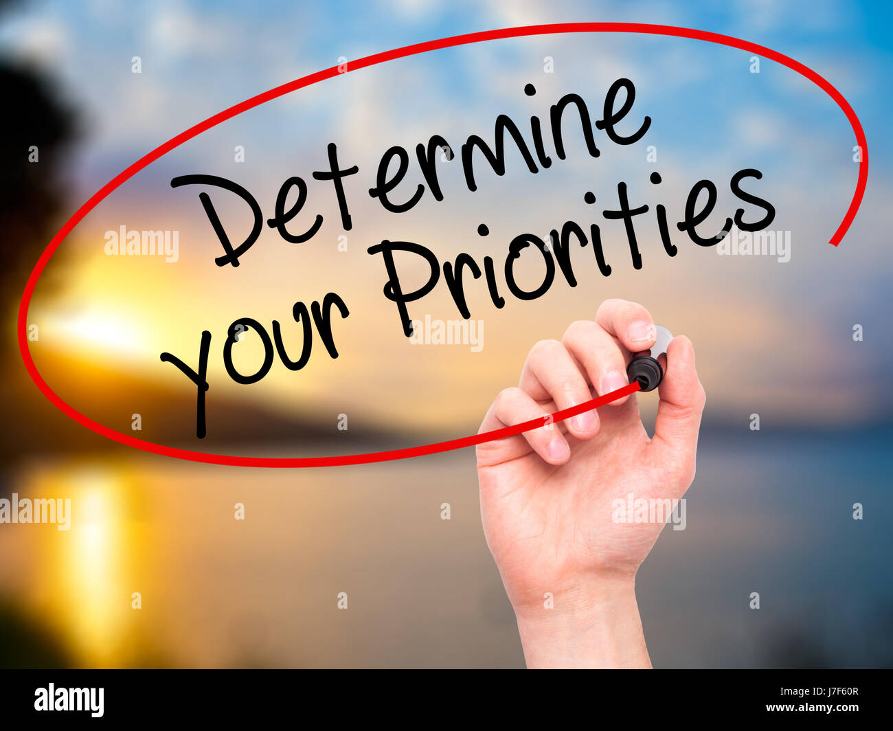 Man Hand writing Determine your Priorities with black marker on visual ...