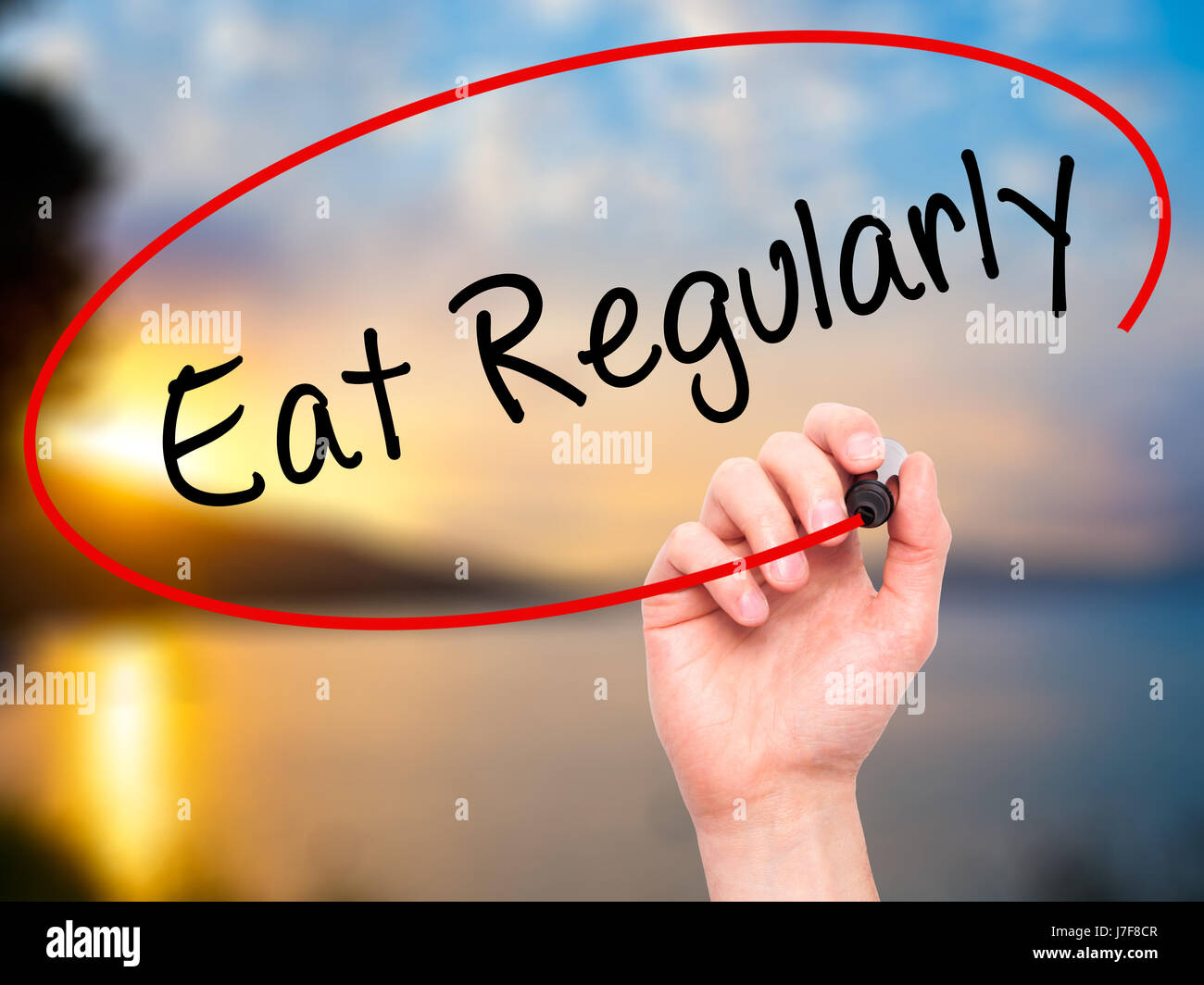Man Hand writing Eat Regularly with black marker on visual screen ...