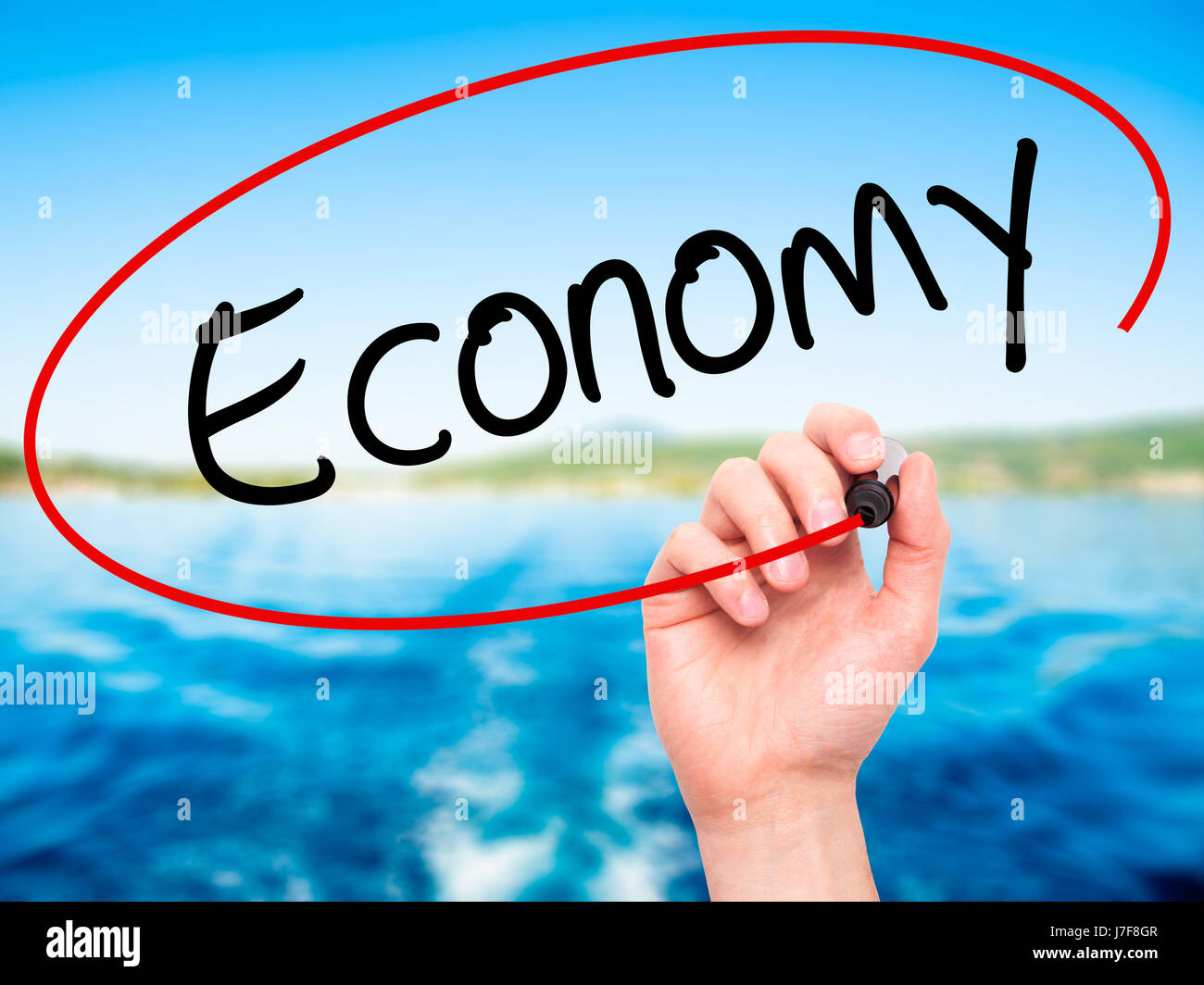 Man Hand writing Economy with black marker on visual screen. Isolated ...