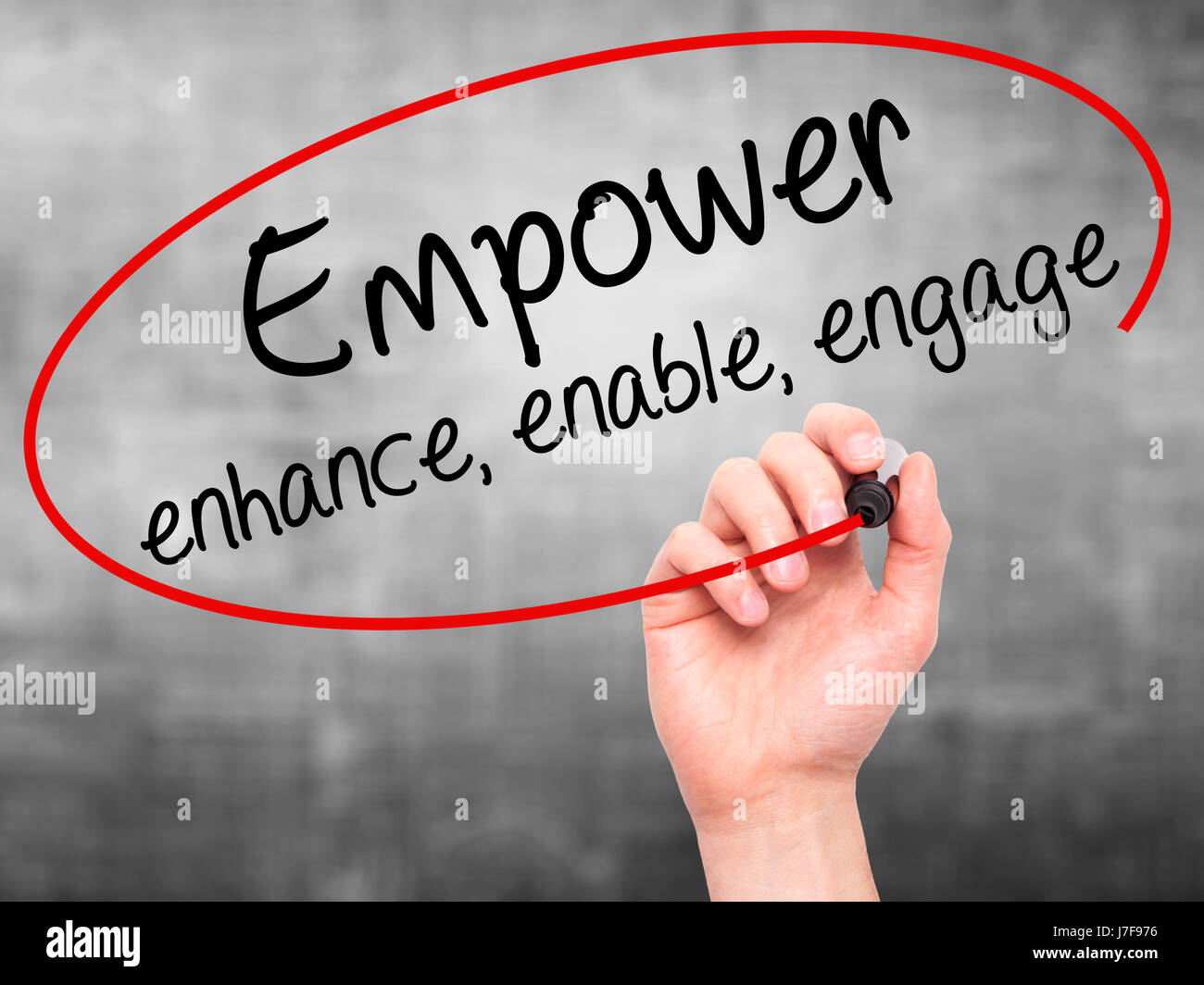 Man Hand writing Empower enhance, enable, engage with black marker on ...
