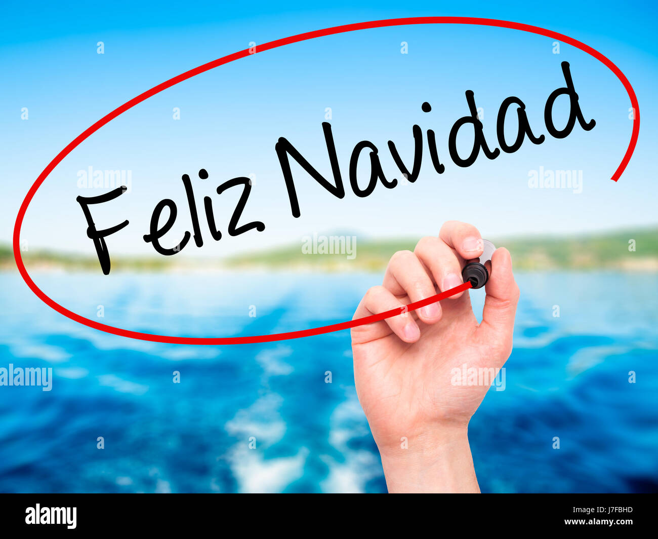 Man Hand writing Feliz Navidad (Merry Christmas In Spanish) with black ...