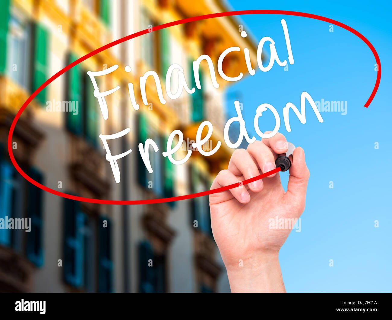 Man Hand writing Financial Freedom with black marker on visual screen ...