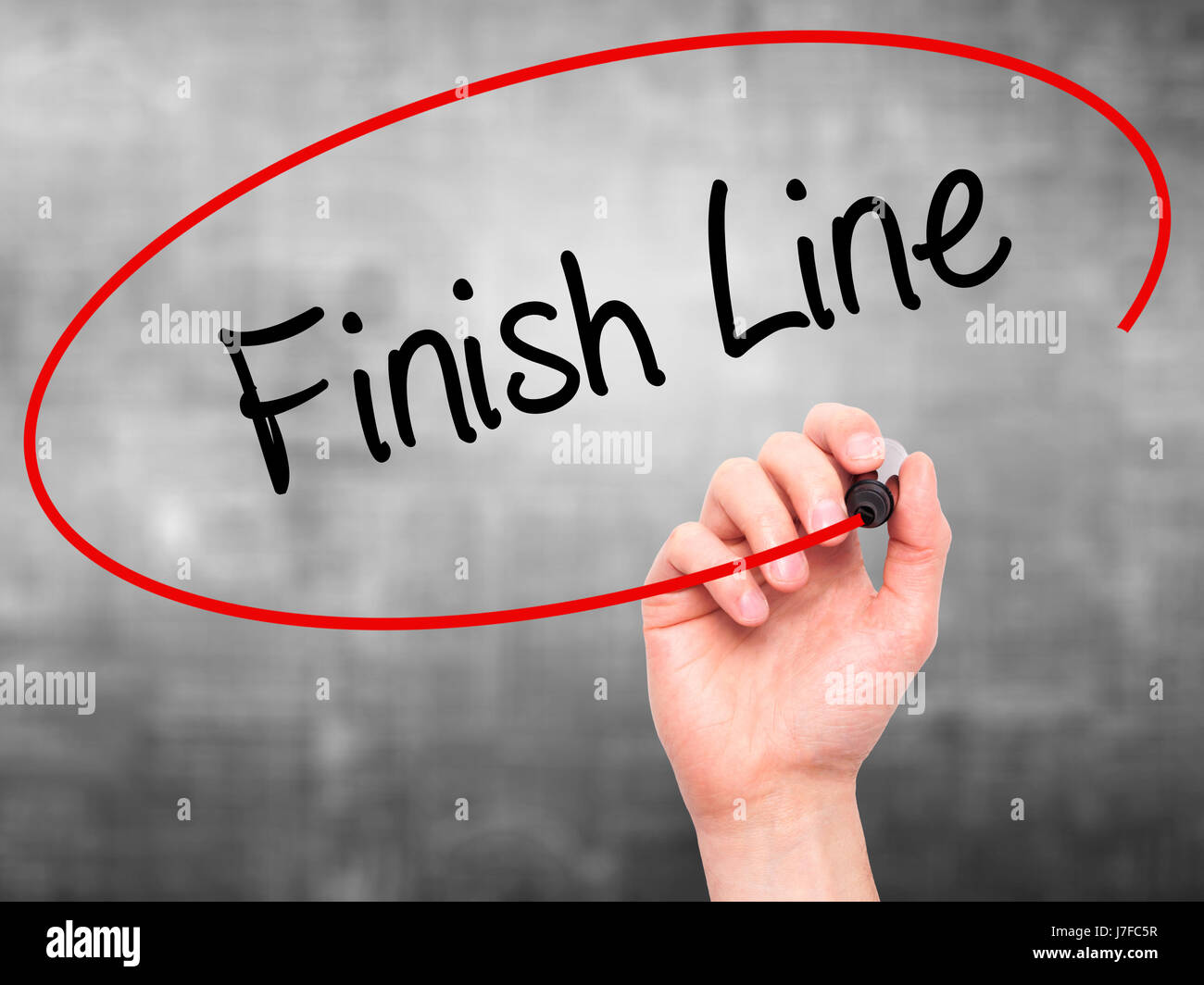 Man Hand writing Finish Line with black marker on visual screen ...