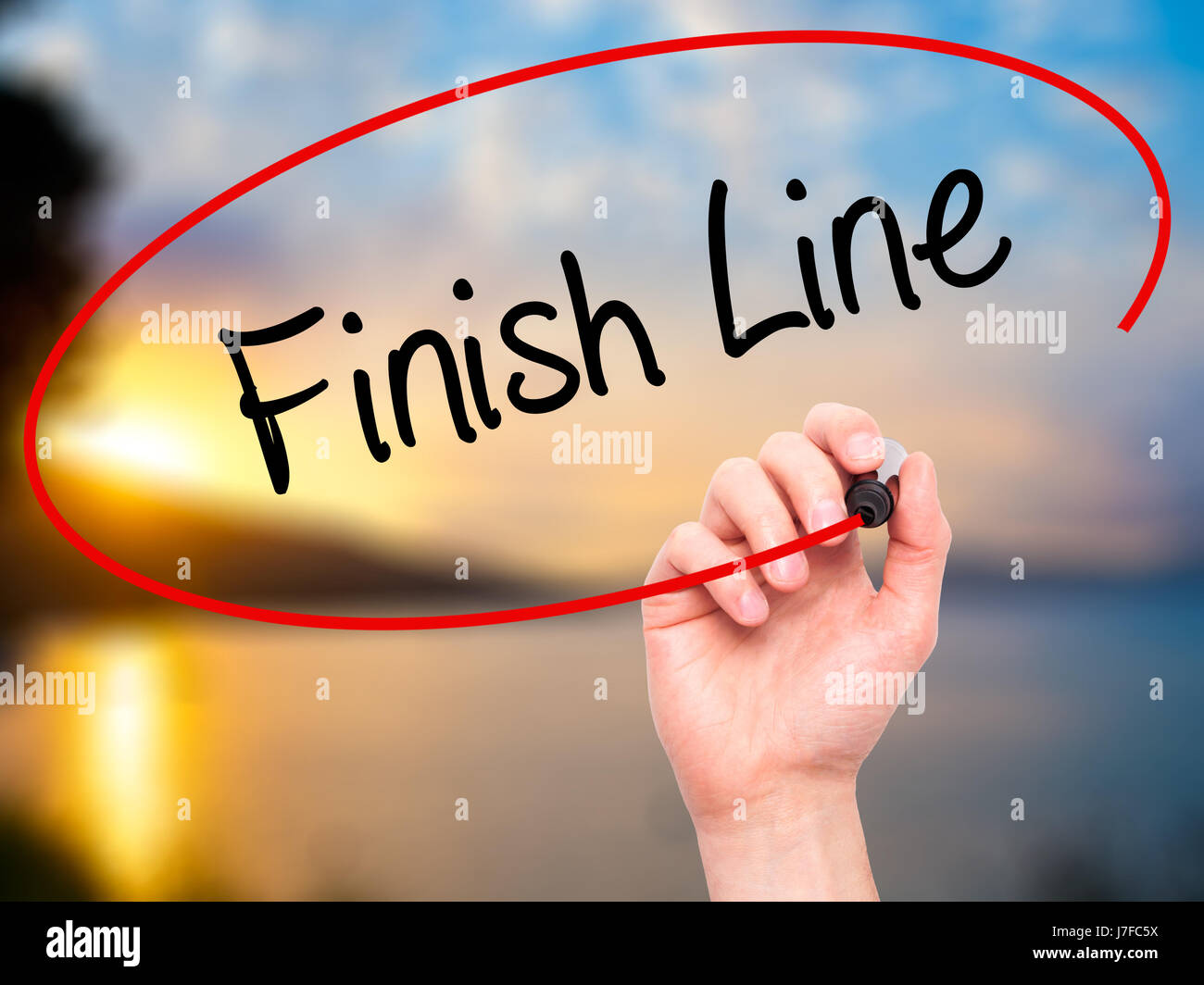 Man Hand writing Finish Line with black marker on visual screen ...
