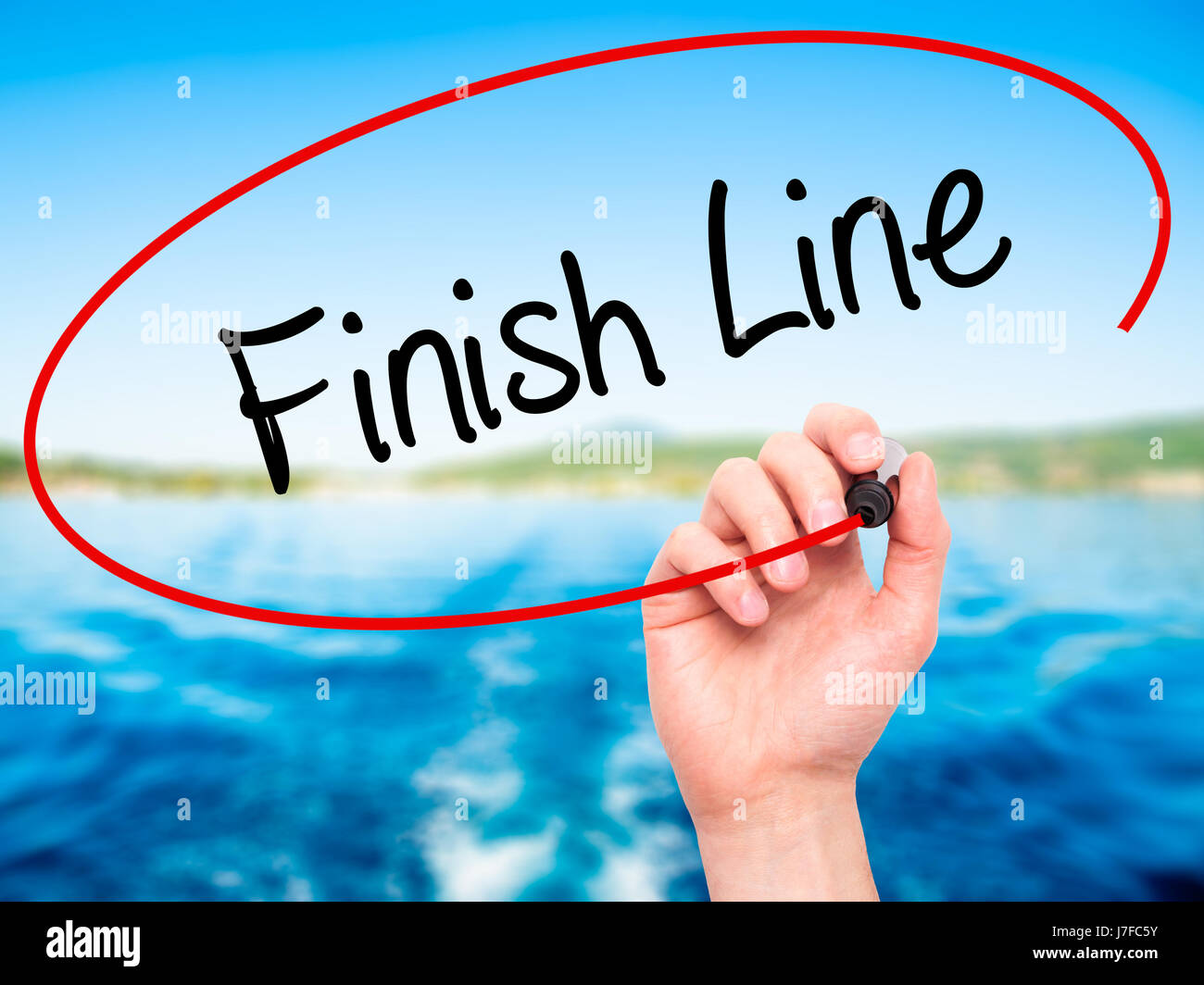 Man Hand writing Finish Line with black marker on visual screen ...