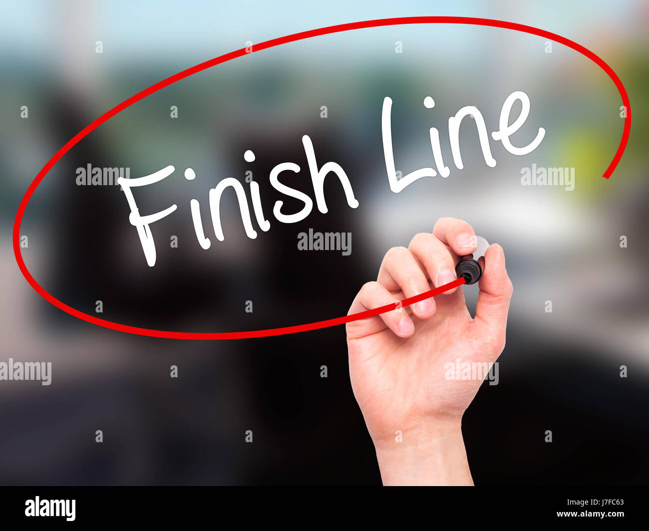 Man Hand writing Finish Line with black marker on visual screen ...