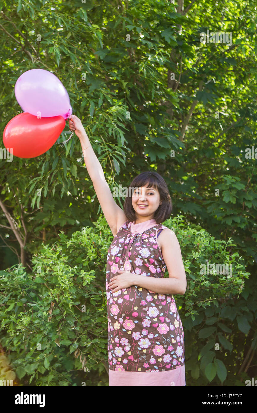 Pregnant woman with colorful balloons in the summer park Stock Photo ...