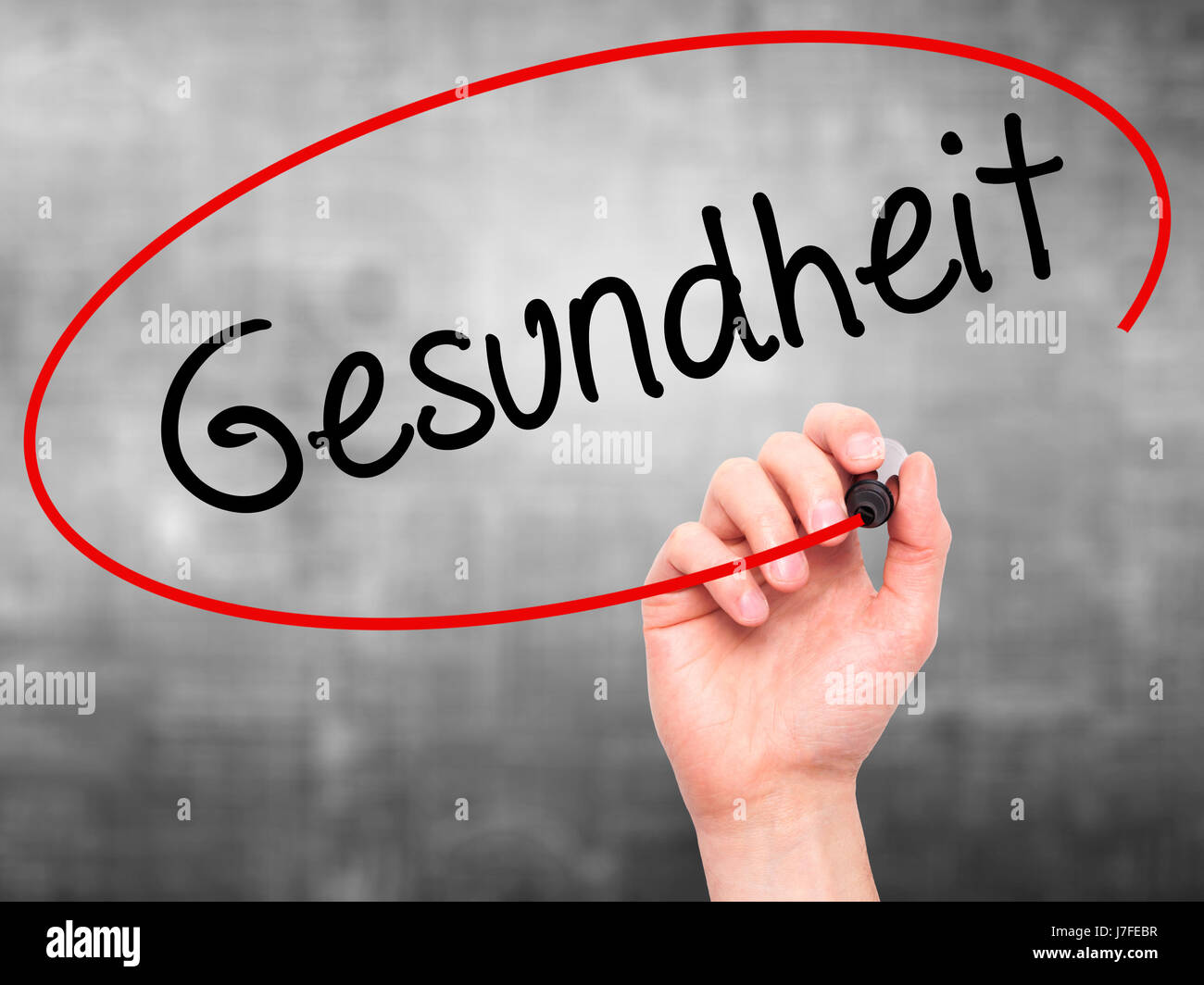 Man Hand writing Gesundheit (Health in German) with black marker on ...