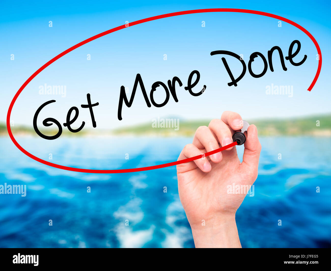 Man Hand writing Get More Done with black marker on visual screen ...