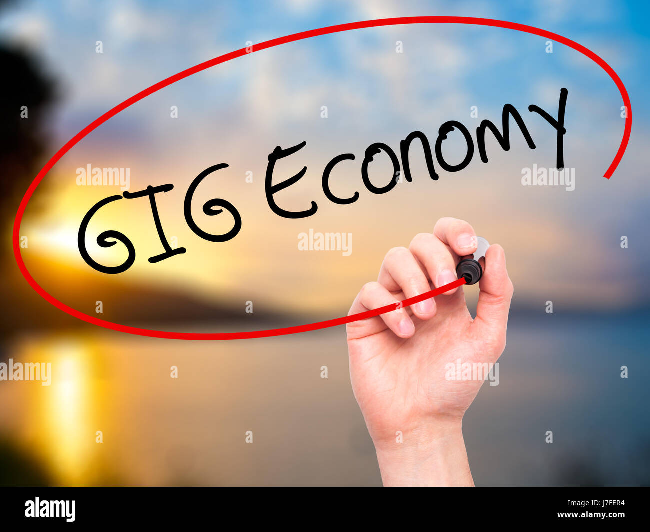 Man Hand writing GIG Economy with black marker on visual screen ...