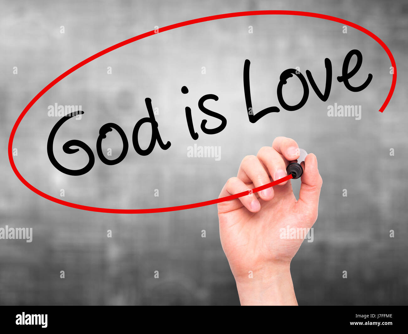 Man Hand writing God is Love with black marker on visual screen ...