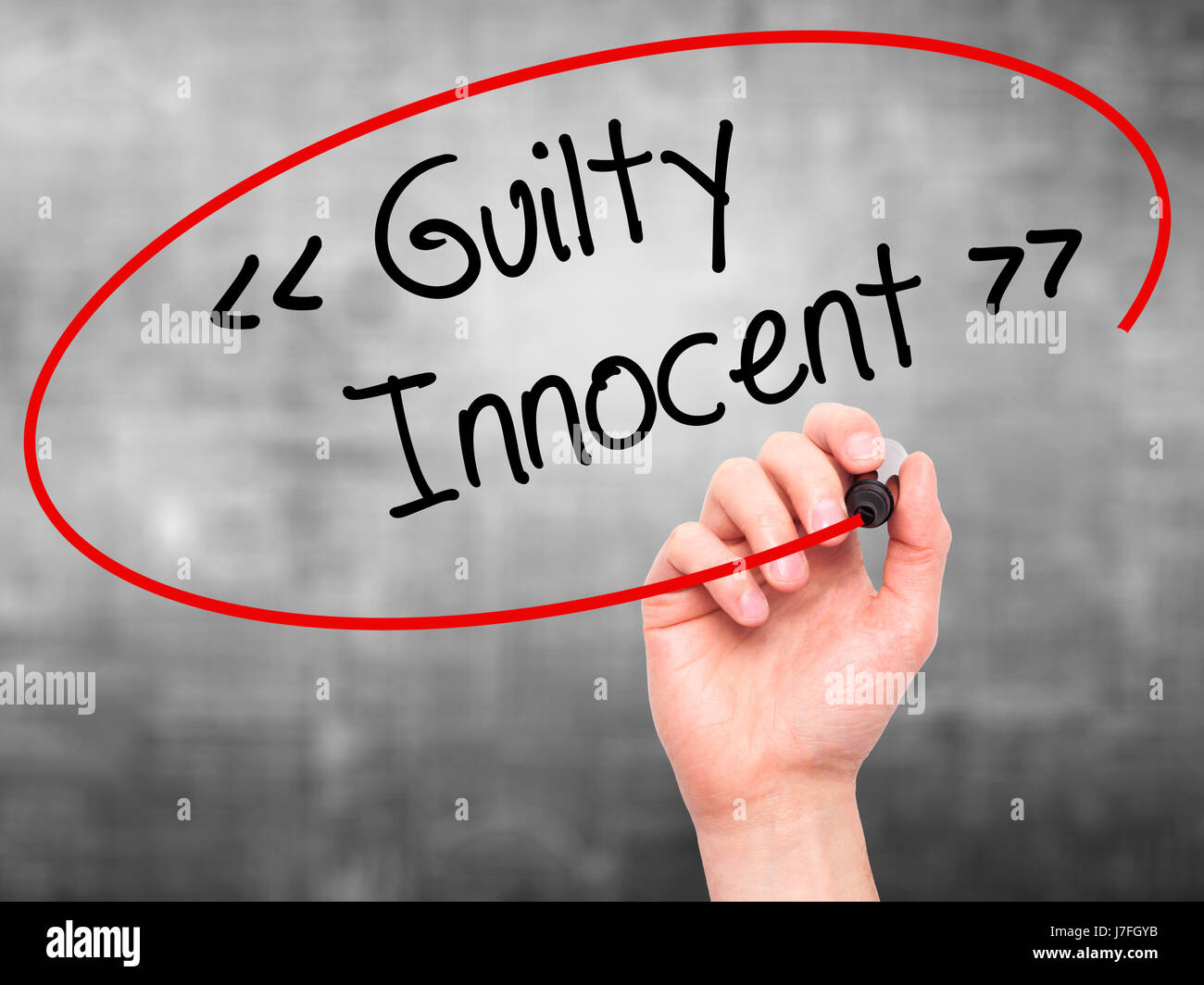 Man Hand writing Guilty - Innocent with black marker on visual screen ...