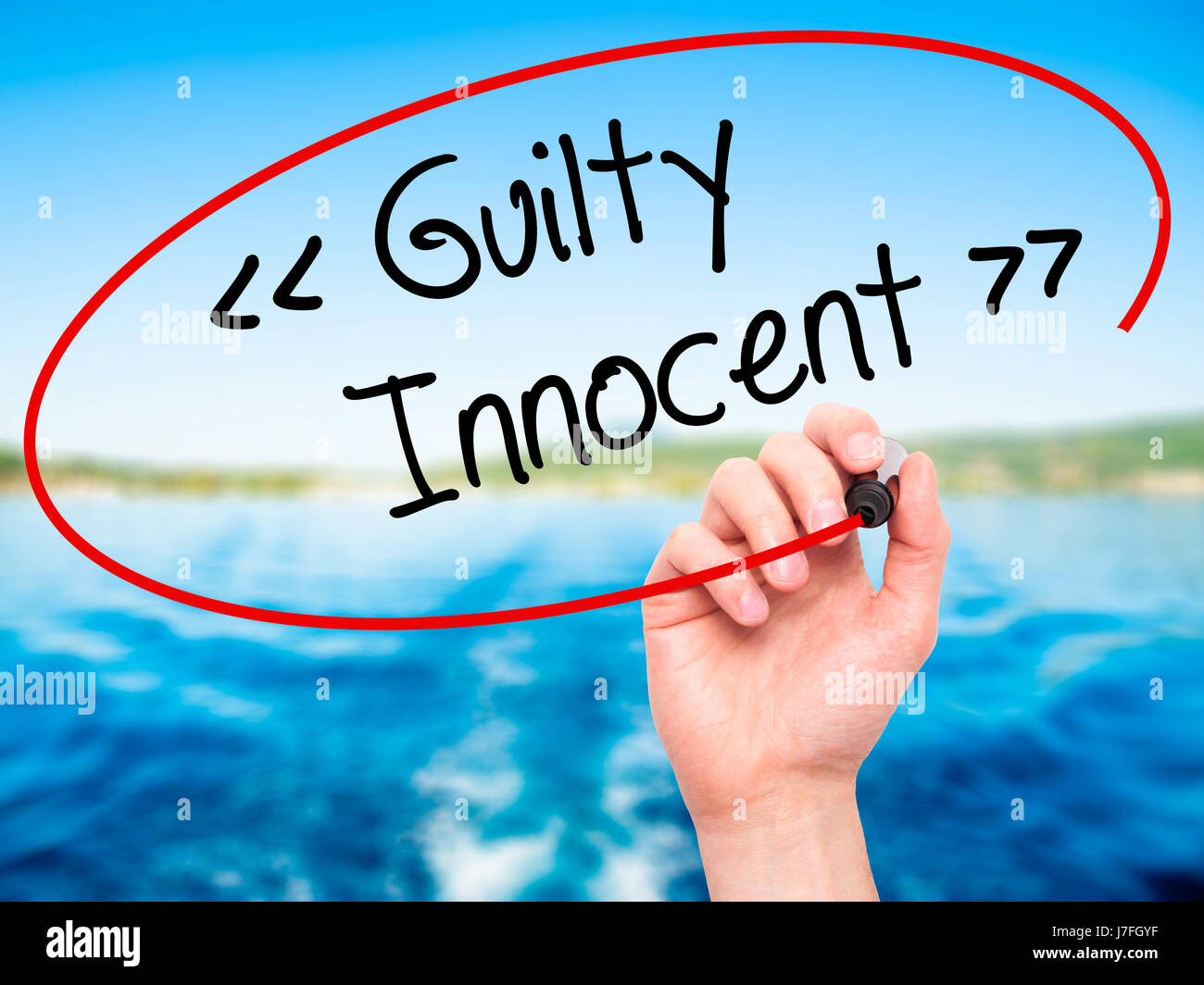 Man Hand writing Guilty - Innocent with black marker on visual screen ...