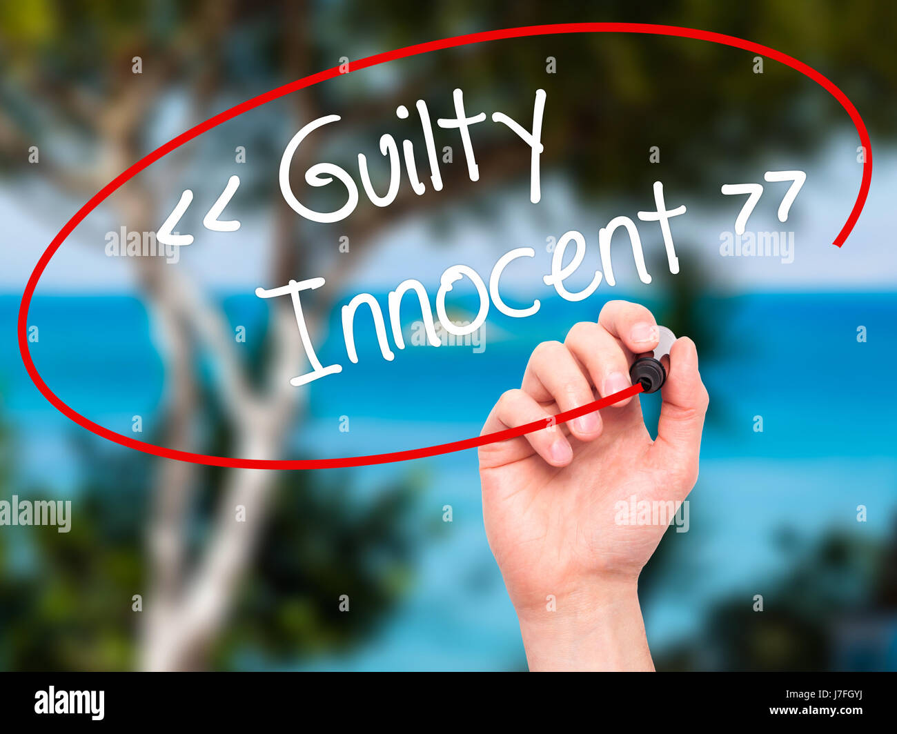 Man Hand writing Guilty - Innocent with black marker on visual screen ...