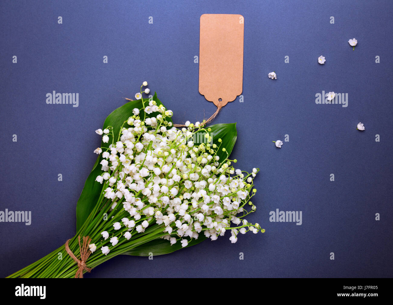 Bouquet of white lily-of-the-valley with an empty paper tag on a rope ...