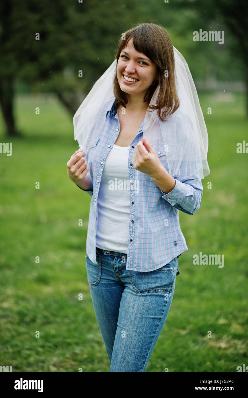 Portrait of brunette girl on checkered shirt, jeans and veil at hen ...