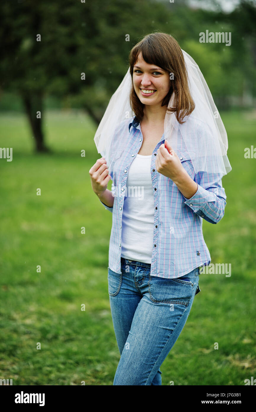 Portrait of brunette girl on checkered shirt, jeans and veil at hen ...