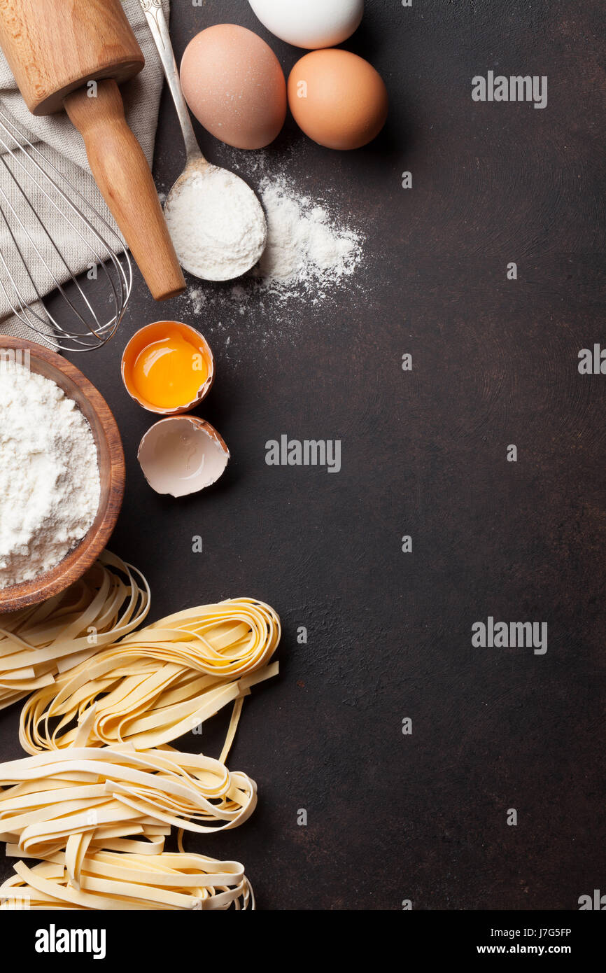 Pasta cooking ingredients on wooden kitchen table. Top view with space ...