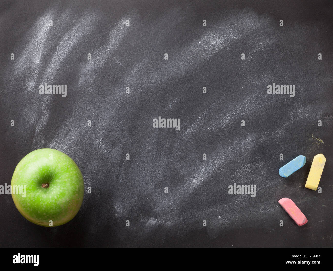 Green apple on blackboard or chalkboard background. Back to school ...