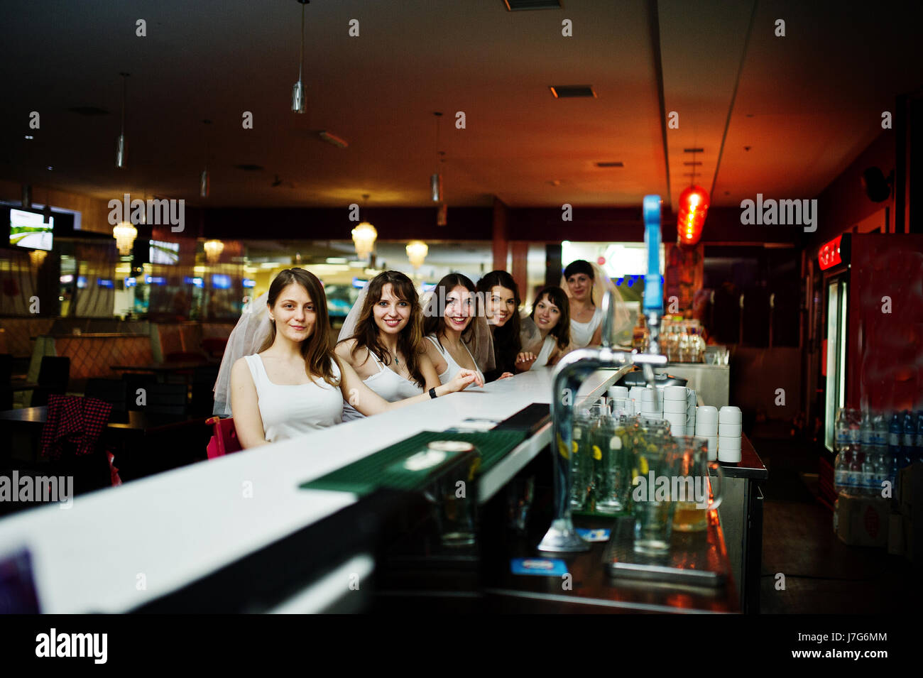 Six girls on veil sit at the bar stools on hen party Stock Photo - Alamy