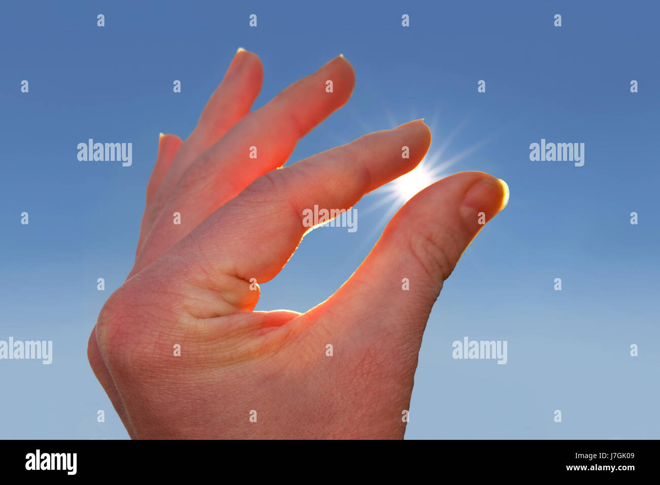 sun with rays between fingers of one hand Stock Photo - Alamy