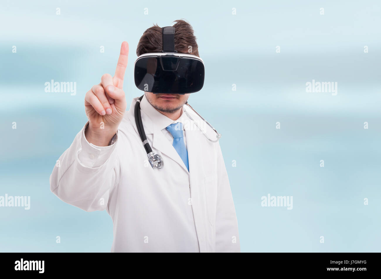 Portrait of doctor pointing one finger up or counting one on blue ...