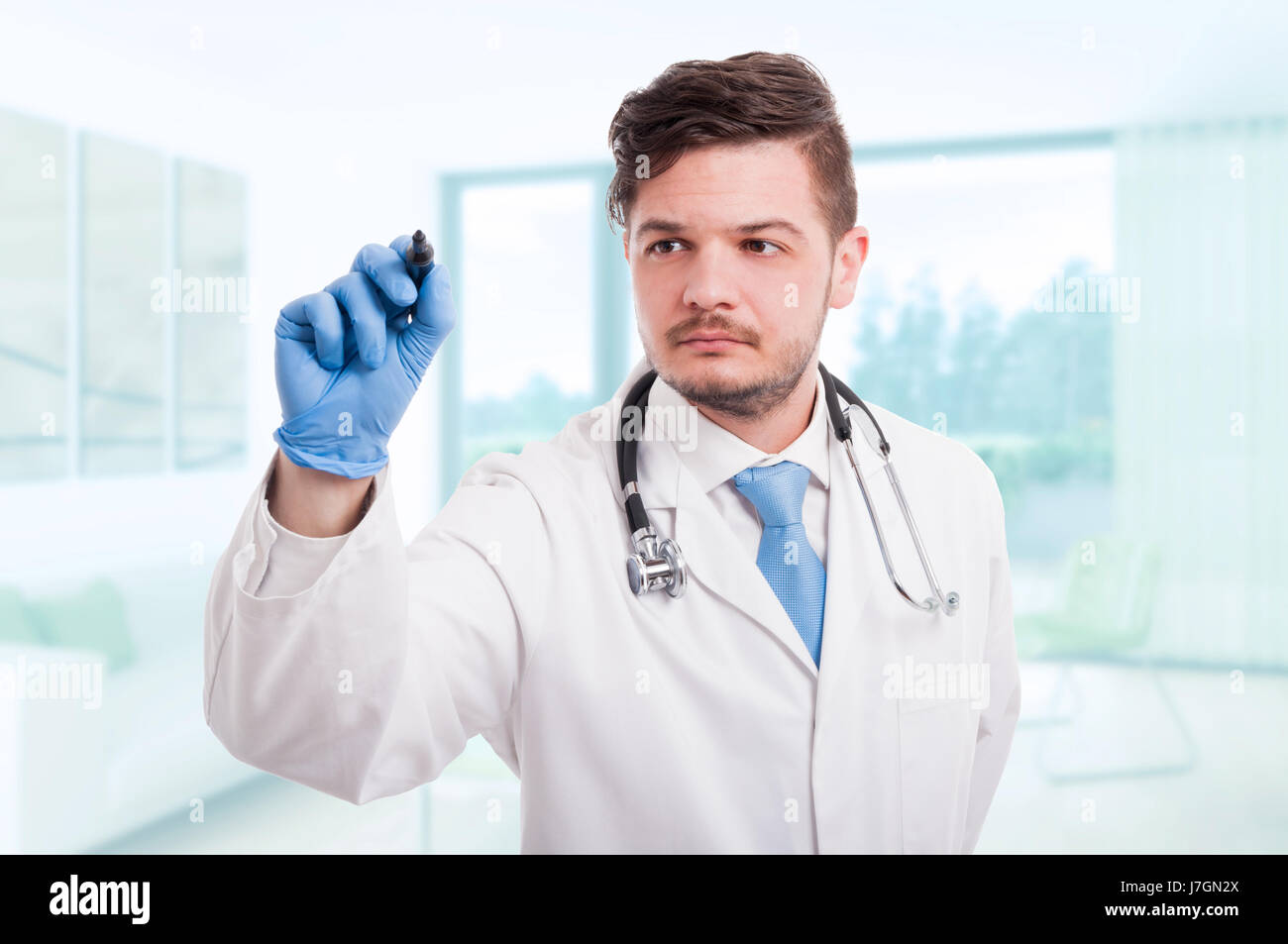 Confident doctor writing something in the air with marker on imaginary ...