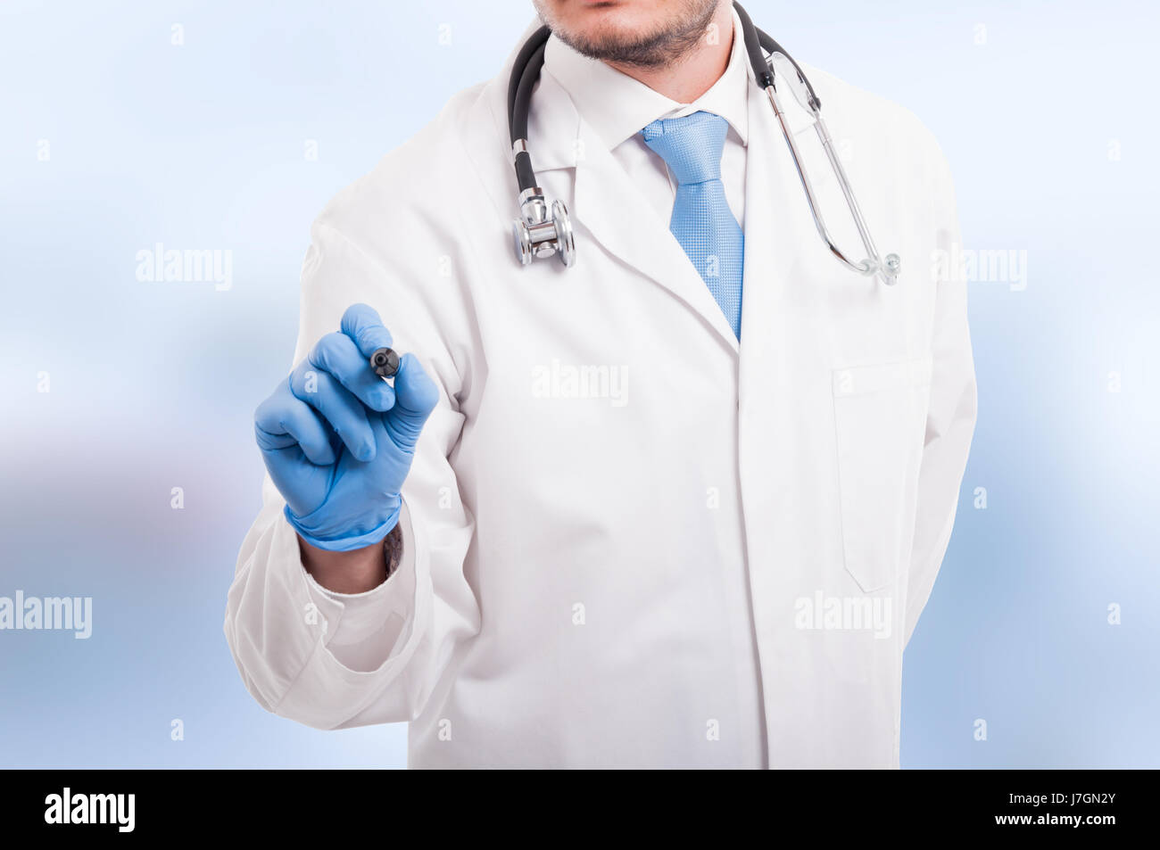 Male doctor writing something with marker on empty screen isolated on ...