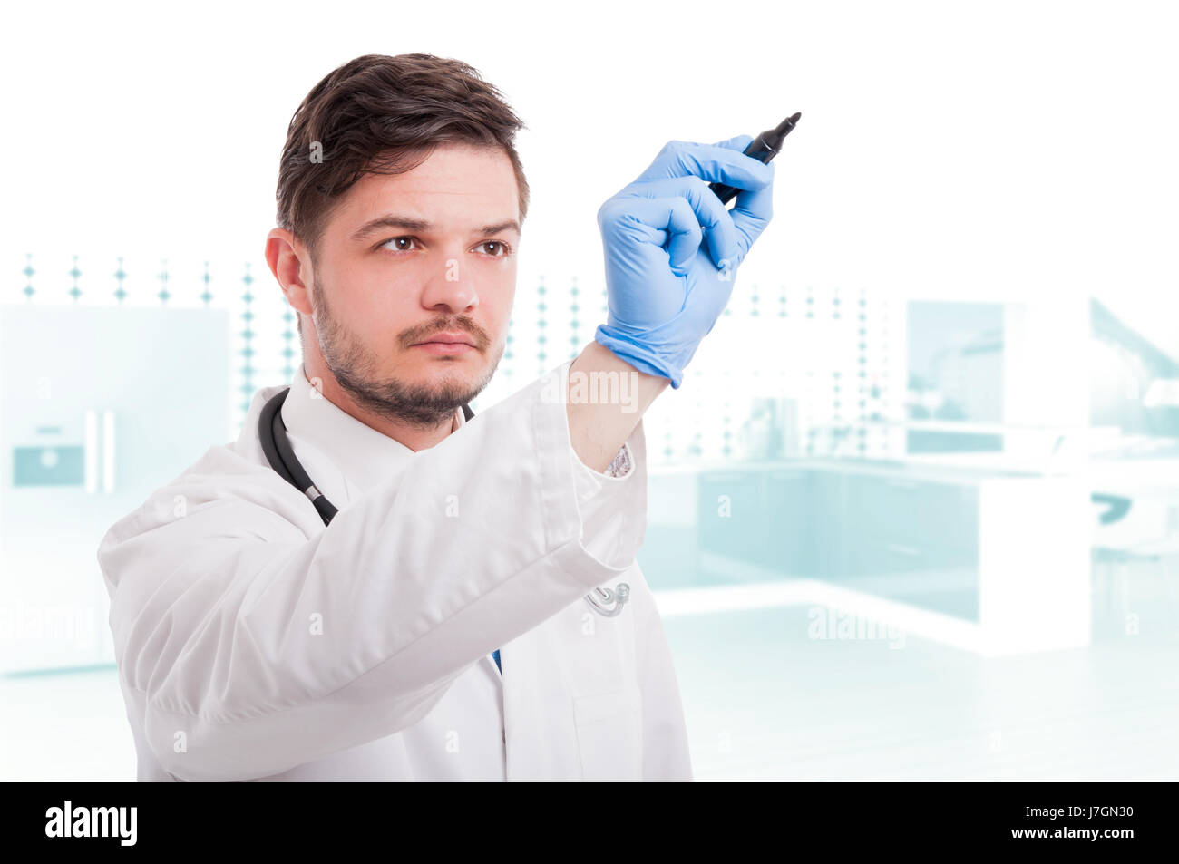 Portrait of attractive medic or doctor writing on modern screen at the ...