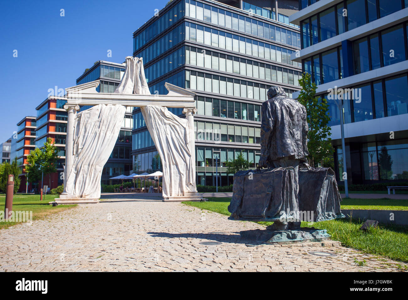 Statue of Timar Jozsef carrying luggages trough Arch Entrance next to ...