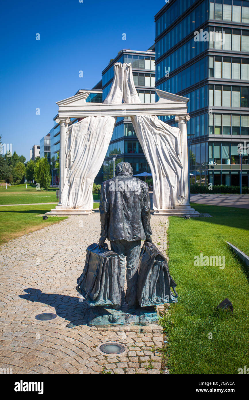 Statue of Timar Jozsef carrying luggages trough Arch Entrance next to ...